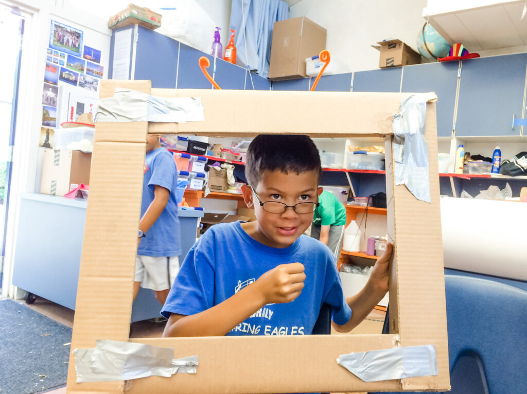 Boy in Cardboard Window
